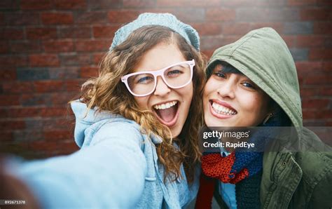 Two Beautiful Girls Take Playful Smiling Selfie Outdoors High Res Stock