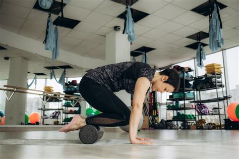 Premium Photo Young Woman Using A Foam Roller While Doing Stretching