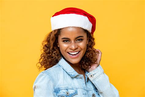 노란 고립 된 배경에 크리스마스 모자를 쓰고 미소 짓는 아프리카 계 미국인 여성의 행복한 초상화 25 29세에 대한 스톡 사진 및 기타 이미지 Istock