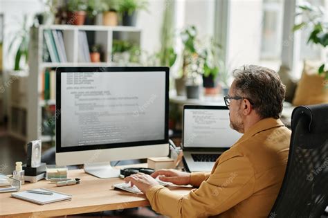 Premium Photo Side View Of Mature Confident Businessman Decoding Data On Computer Screen