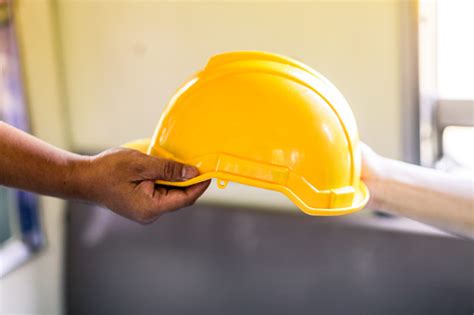 햇빛을 가진 도시에 콘크리트 바닥에 건설 현장 건물에서 프로젝트에 노란색 안전 헬멧 모자 보기 엔지니어 노동자로 장인을 위한 헬멧 개념 안전 제일 0명에 대한 스톡 사진 및