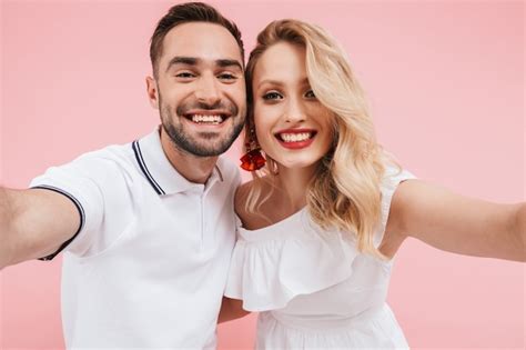 Atractiva Pareja Joven Alegre En El Amor De Pie Juntos Aislados Sobre Rosa Tomando Un Selfie
