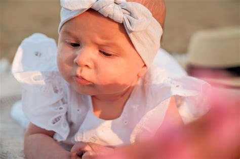 La Petite Fille Nouveau Née Se Trouve Sur La Plage Dans Une Robe