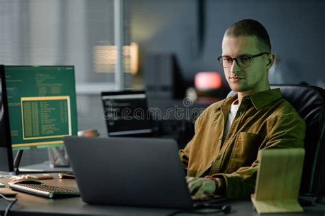 Male Computer Programmer Coding On Laptop Sitting At Desk In It Company