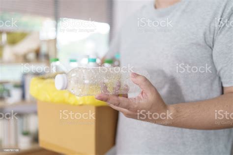 홈 재활용 에코 그린 제로 개념 남자는 집에서 노란색 쓰레기 봉투와 함께 재활용 쓰레기통에 빈 플라스틱 병을 던진다 가방에 대한