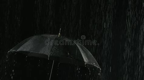 An Open Black Umbrella In The Rain Through Which Streams Of Water Flow