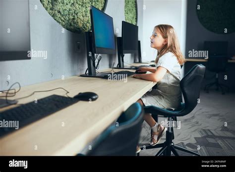 Absorbed Schoolgirl Learning To Use Technology In Classroom At Primary