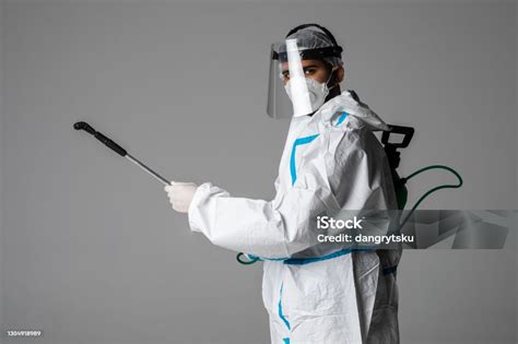 흰색 배경에 스프레이와 함께 크기 조정 헤이즈마트 정장에 메딕 남자의 전체 길이 프로필 샷 감염에 대한 스톡 사진 및 기타