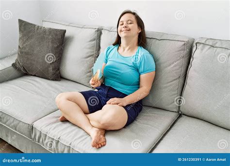Brunette Frau Mit Daunensyndrom Sitzend Auf Dem Sofa Mit Handventilator
