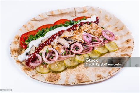 칠면조 토마토 피클 절인 양파 다진 파슬리와 마늘 소스 고립 된 흰색 배경에 토마토 소스를 곁들인 Shawarma를 열었습니다