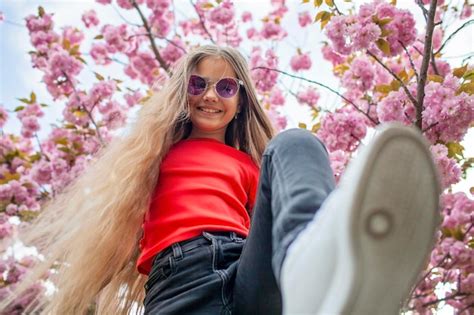 Premium Photo Playful Girl With Sunglasses Among Pink Blossoms