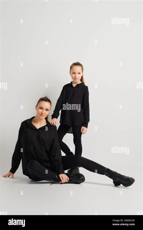 Mother Sits On The Floor Stretching One Leg To The Side And Her