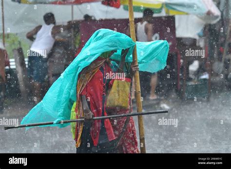 Commuters Make Their Way On A Waterlogged Street During Heavy Rains In