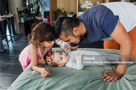 두 자녀 아기 아들과 딸이 멕시코 라틴 아메리카의 집에서 침대에서 함께 즐거운 시간을 보내는 라틴 가족 히스패닉계 어머니와 아버지 18 23 개월에 대한 스톡 사진 및 기타