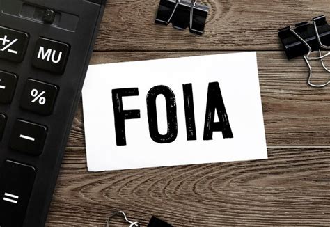 Premium Photo White Paper With Text Foia On A Wooden Surface With Stationery