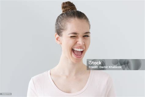 행복 하 고 활기찬 오픈 입으로 미소 하 고 윙크 하는 그녀는 여가 시간 및 활동에 대 한 좋은 아이디어를 제안 하는 경우 회색