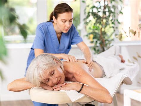 Blurry Unrecognizable Woman Performs Shoulder Massage To Female Client