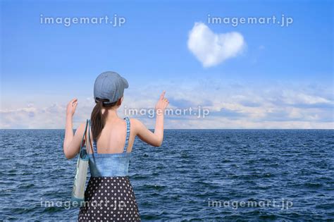 海に浮かぶハートの形をした雲を指さすカジュアルな服装の女性のイラスト素材 119929477 イメージマート