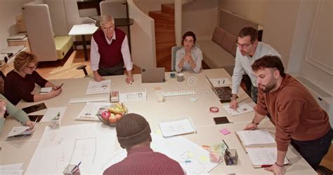 A Multi Generational Team Collaborates At A Conference Table Discussing Business Strategies And