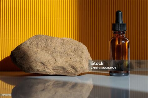 스킨 케어 에센스 오일 드롭퍼 유리 병과 돌 노란색 배경 보습 세럼 얼굴 의 피부를위한 비타민 미학 미니멀리즘 0명에 대한 스톡