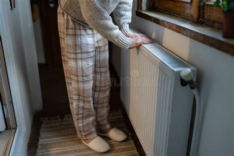 Closeup Of Woman Warming Her Hands On The Heater At Home During Cold