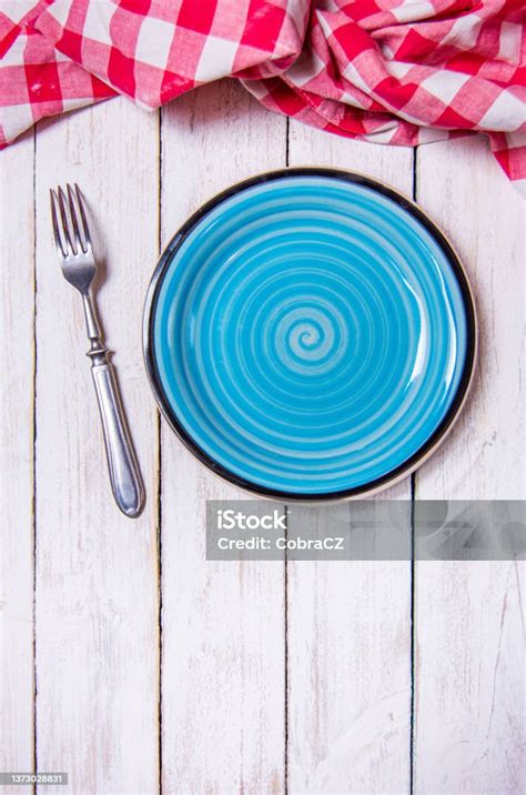 빈 파란색 세라믹 플레이트 빈티지 풍화 흰색 나무 보드에 골동품 실버 칼붙이와 상단 보기 배경 복사 공간을 참조하십시오 빨간 체크 주방 수건 세로 사진 고풍스런에 대한 스톡