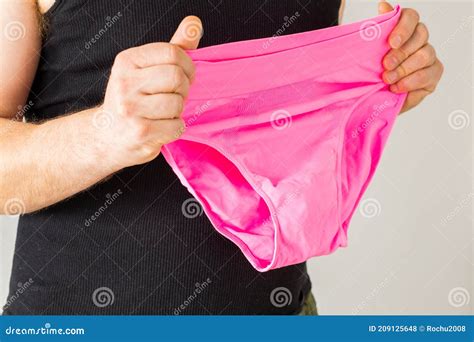 El Tipo Masculino De Un Hombre Sostiene Bragas Rosas En Sus Manos Foto