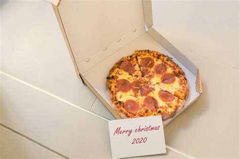 피자와 카드의 상자를 열고 현관 현관에 집 문앞에 텍스트 메리 크리스마스 2020 배달 개념 0명에 대한 스톡 사진 및 기타