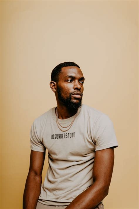 텍스트가 있는 베이지색 티셔츠를 입은 남자의 초상화 · 무료 스톡 사진