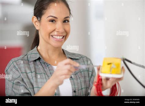 A Girl Repairs An Electrical Switch With A Screwdriver Stock Photo Alamy