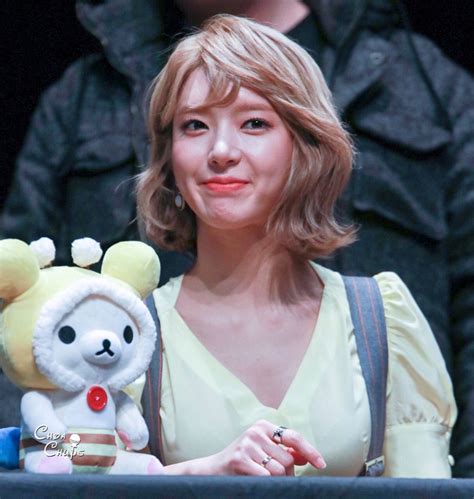 A Woman Holding A Stuffed Animal In Her Hand