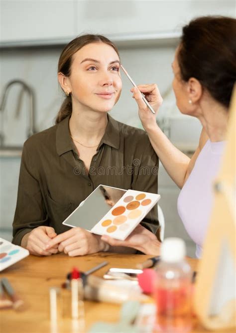 Makeup Artist Carefully Shaping Eyebrows To Young Woman Stock Image