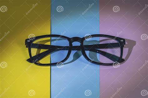 Black Eyeglasses Casting Shadows On Colorful Geometric Background Stock