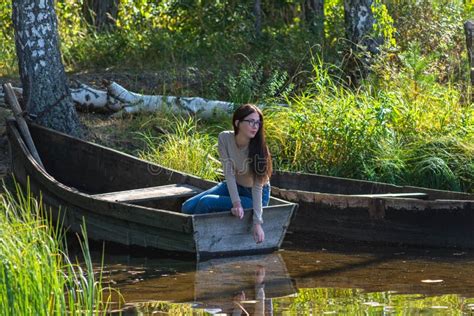 Girls Sits In A Wooden Boat And Looks Into The Distance Close Up Stock