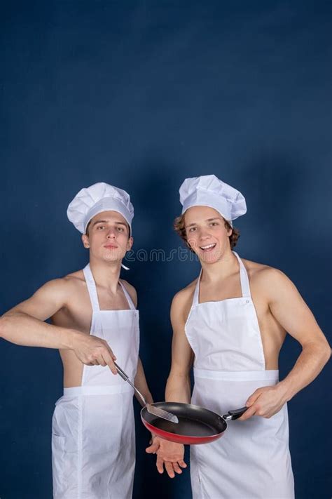 Two Handsome Chefs With Apron On Naked Muscular Body With Kitchen
