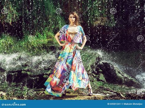 Beautiful Fashion Model Posing In Front Of A Waterfall Stock Image