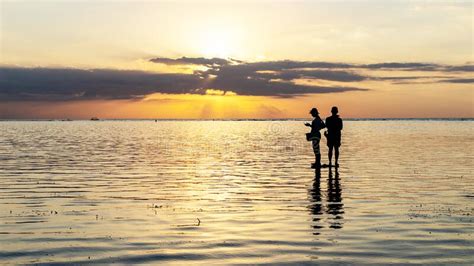 Silueta De Una Pareja Caminando Por La Playa Al Atardecer En Indonesia