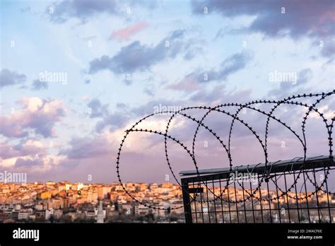 Sunset Sky And Barbed Wire Over A City Barbed Wire Fence Restricted