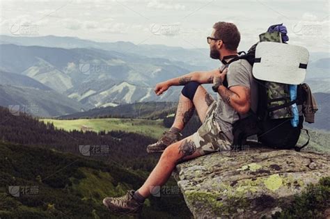 青年男子站在悬崖顶部的夏季山