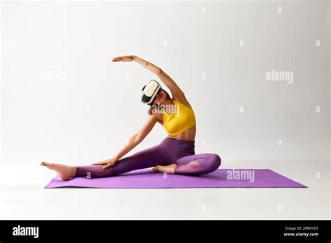 Stretching Flexible Sportive Young Girl Doing Yoga Exercises In Vr