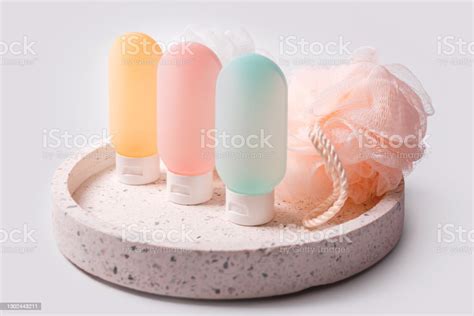 대리석 트레이에 수건으로 샴푸 헤어 밤 샤워 젤을 위한 다채로운 플라스틱 용기 가벼운 배경에 스파 및 목욕 액세서리화장품