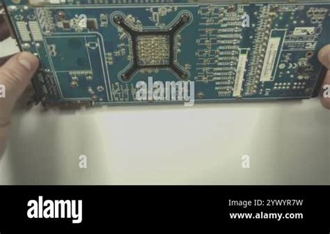 Person Handling And Examining A Computer Graphics Card Showcasing Its