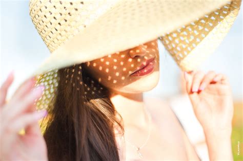 Девушка в шляпе летнее фото с солнечными бликами на лице