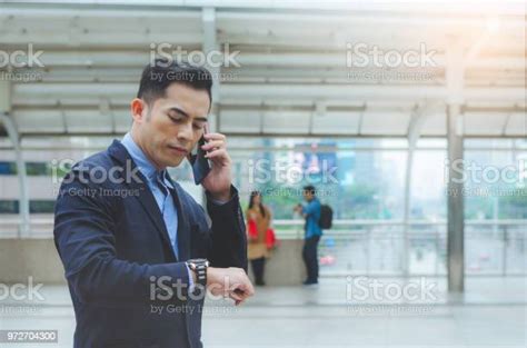 세로 매력적인 잘생긴 사업가 스마트폰 얘기 하 고 작업 시간을 확인 하는 스마트 시계를 찾고 경영자에 대한 스톡 사진 및 기타