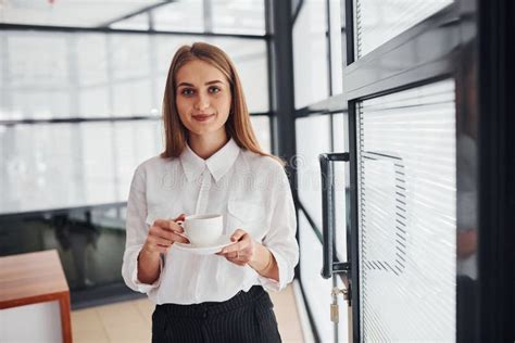 Female Office Worker In Formal Clothes Standing Indoors At Daytime With