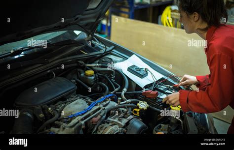 Female Mechanic Testing Car Battery With Multimeter Tool Stock Photo Alamy