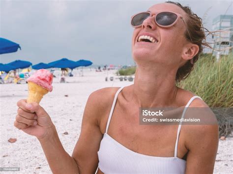 해변에서 행복 한 여자는 플로리다에서 하얀 모래 해변을 즐기는 여름에 아이스크림을 먹고 관광객에 대한 스톡 사진 및 기타 이미지