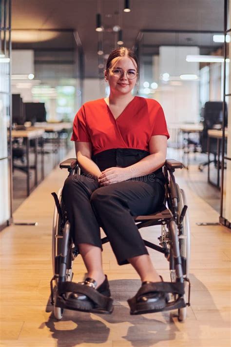 A Modern Young Businesswoman In A Wheelchair Is Surrounded By An