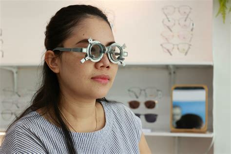 Eye Exam Concept Woman Eye Test In Clinic Beautiful Girl Wearing Eyeglass On Blur Optical Shop