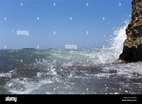 Sea Wave Splashing Over The Shore Rocks With A High Sea Spray Stock